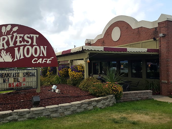 The iconic burgundy sign of Harvest Moon Cafe stands proud against Michigan skies, promising comfort food that delivers on every level.