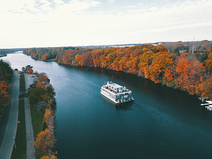 An aerial view reveals the Michigan Princess in all its glory, cutting through autumn foliage like a white ghost on water.