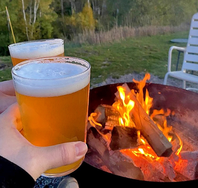 Golden brews catch firelight at sunset &ndash; Farm Club's house-crafted beers are the perfect companion to Michigan evenings.