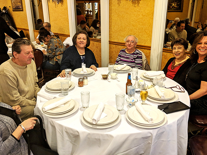Multi-generational families gather around tables set with care, creating memories between bites of authentic Italian cuisine.