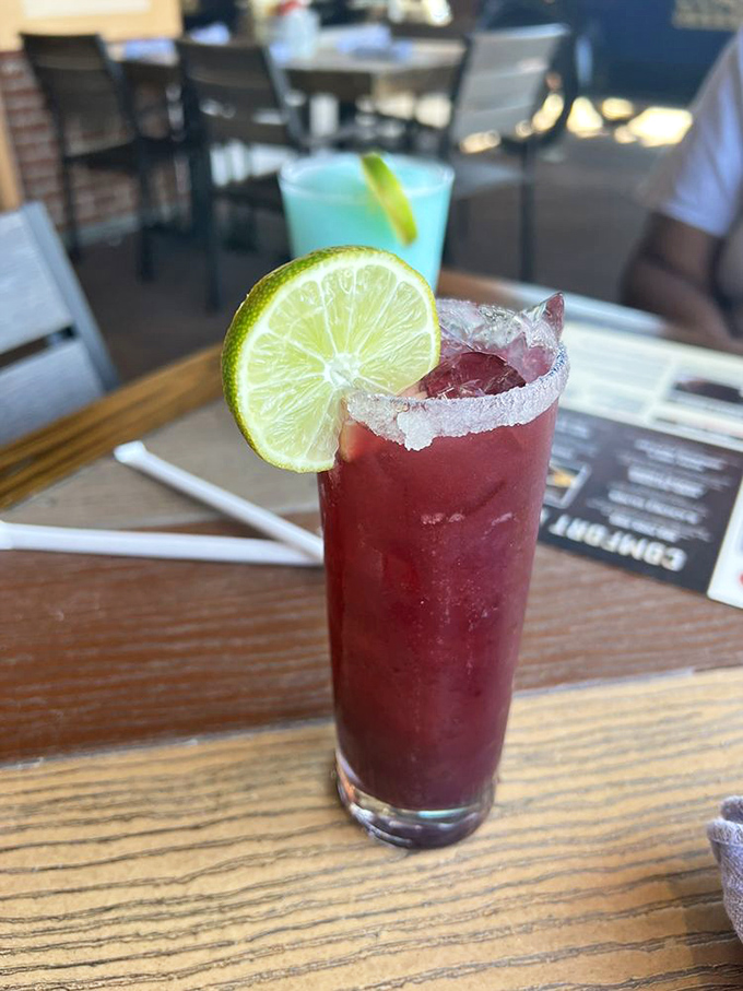 This vibrant cocktail, rimmed with salt and garnished with fresh lime, offers a refreshing pit stop between bites of hearty garage-inspired fare.