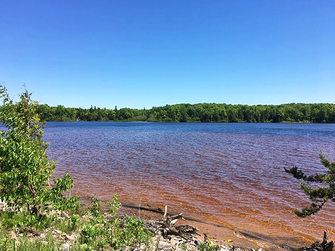 Morning light reveals Grand Sable's rusty undertones, a reminder of the region's rich mineral history beneath crystal waters.