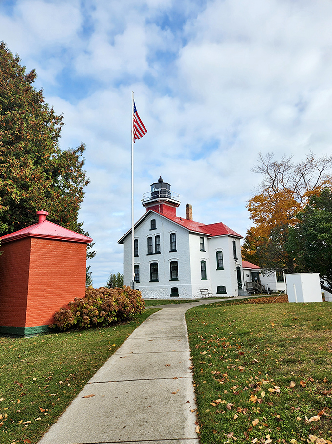 Grand Traverse Lighthouse has guided sailors through treacherous waters since 1852, its white walls and red roof a reassuring beacon against Michigan's sometimes moody skies.