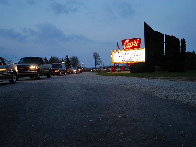 Capri marquee beckons like a lighthouse for entertainment-seekers, cars lining up for their cinematic pilgrimage as dusk embraces the Michigan countryside.