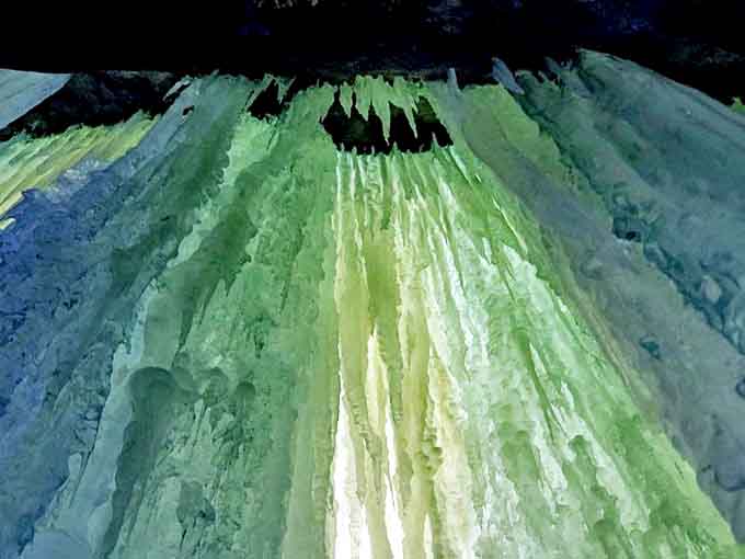 Ice formations capture light in their crystalline structure, transforming ordinary water into glowing green and blue masterpieces.