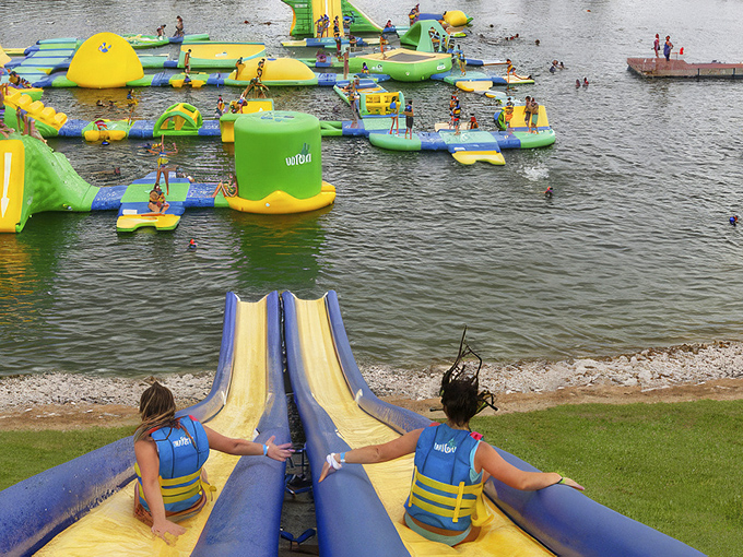 Visitors celebrate victory after conquering the slide obstacles, their bright life jackets ensuring safety while they build confidence and create lasting memories.
