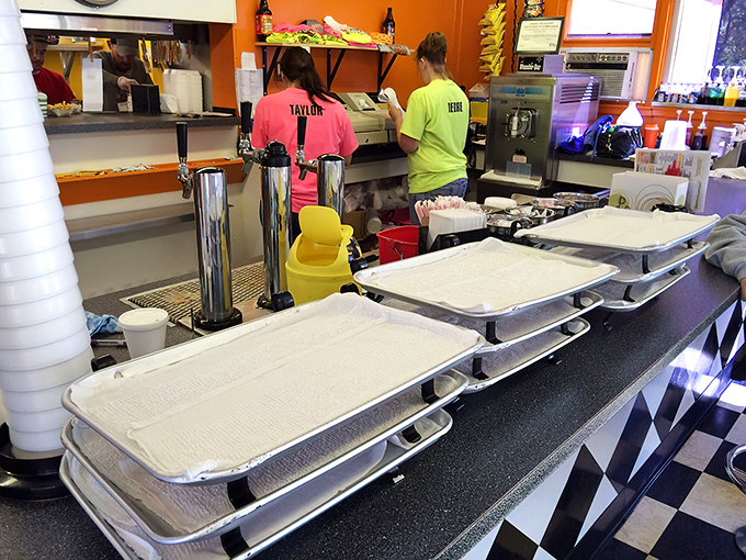 The bustling kitchen where magic happens, staff working with the choreographed precision that comes only from years of flipping burgers and dressing dogs.