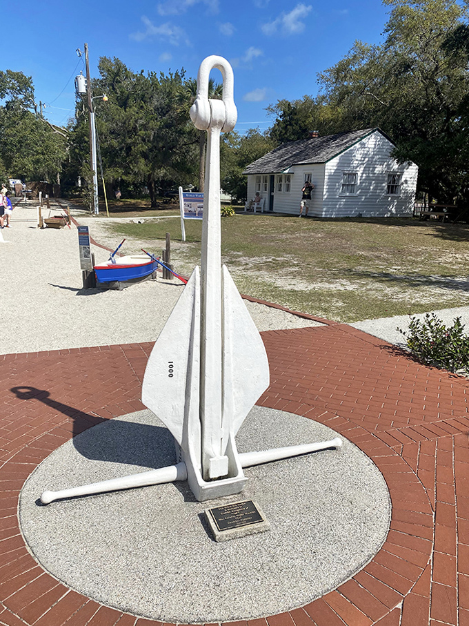 This stark white anchor monument honors those lost at sea, a solemn reminder of why lighthouses became essential coastal sentinels.