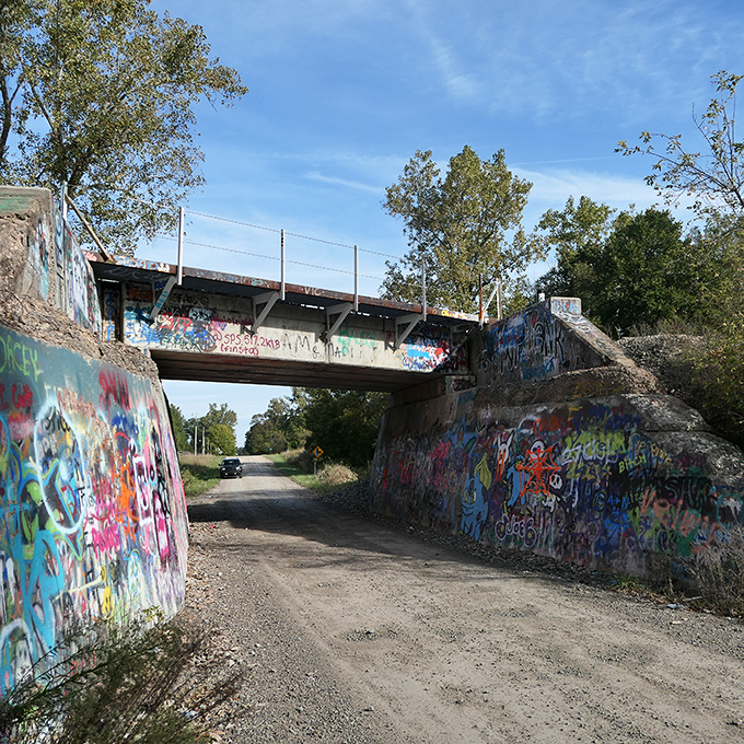 The bridge's sturdy construction has withstood decades of Michigan weather, providing a permanent canvas for temporary art.