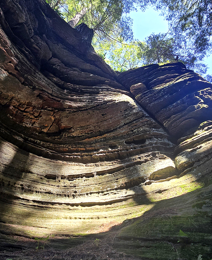 Looking up from the canyon floor reveals a sliver of sky between towering walls. The perspective makes visitors feel delightfully small in nature's grand architecture.