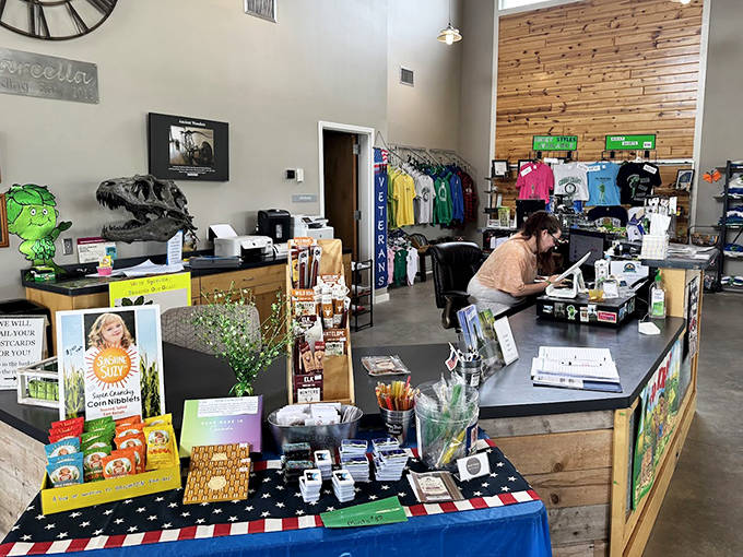 Friendly staff at the welcome center counter offer information about the giant and other local attractions while surrounded by green-themed souvenirs.