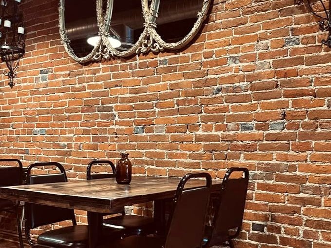 Rustic wooden tables against exposed brick create cozy corners where conversations flow as freely as the exceptional coffee.