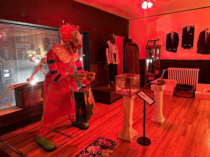 This oversized clown figure looms menacingly in the red-lit room, daring visitors to maintain their composure while passing by.