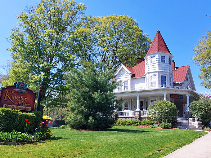 Morning light bathes the white clapboard and red roof in golden hues, making even non-morning people appreciate the dawn.