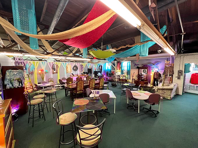 The community gathering space invites connection and conversation under a canopy of colorful fabrics that dance overhead.