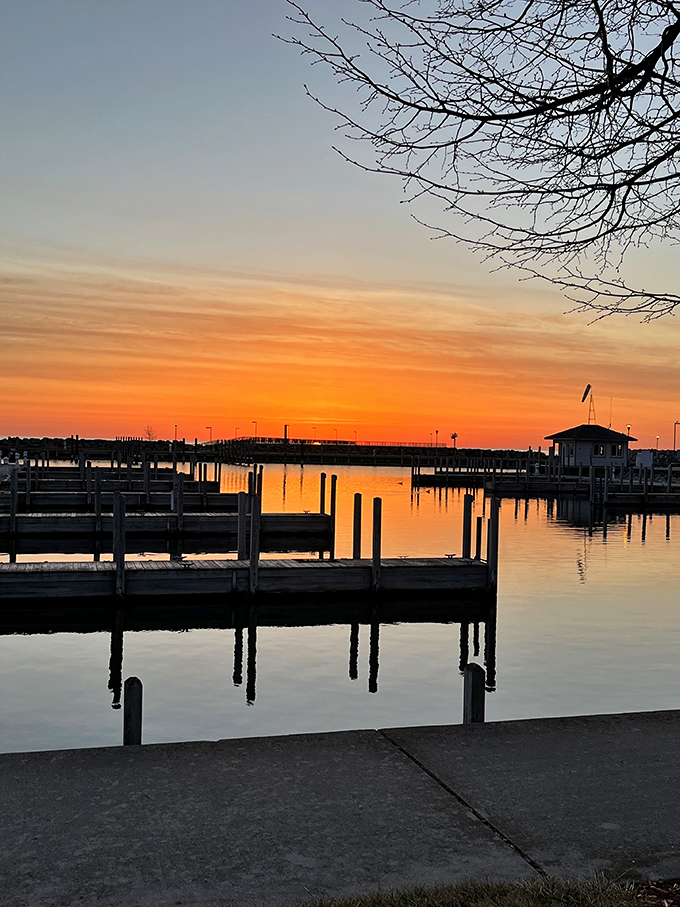 Sunset transforms the marina into a painter's palette of oranges and purples, silhouetting boats against the fading light. 