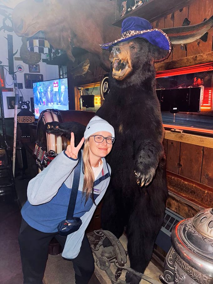 A visitor poses with one of Stubb's most famous residents &ndash; a towering bear sporting a jaunty blue hat with surprising fashion sense.