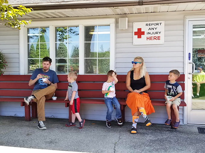 Families gather on benches throughout the park, taking breaks between activities and probably debating who's winning at everything.