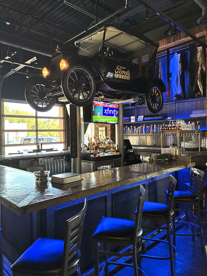 The bar area steals the show with an actual vintage Model T suspended overhead and a bar top resembling a running board, mixology meets automotive museum.