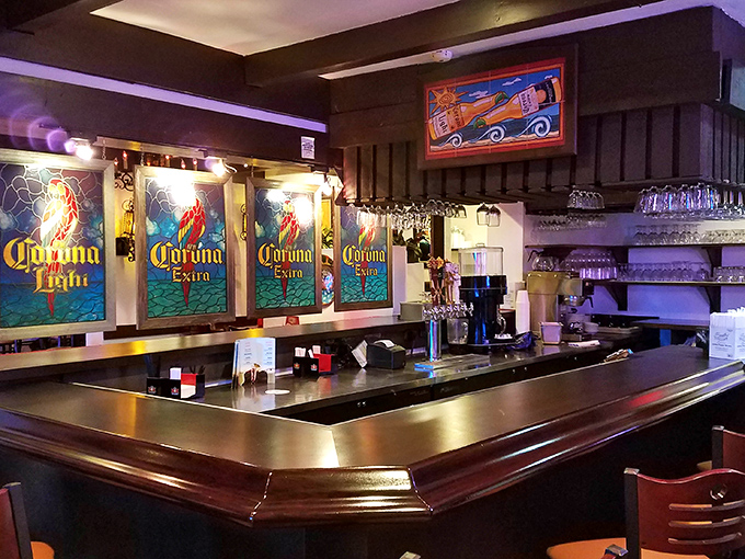 The bar's Corona-illuminated backdrop creates the perfect mood lighting for sipping specialty margaritas and watching the bartender's mixing magic.