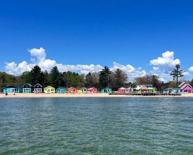 Morning light bathes the colorful cottages in gold, promising another perfect day in this Great Lakes paradise.