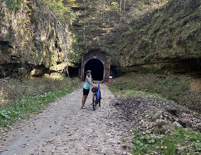 A cyclist pauses before entering the mysterious darkness, where 1870s engineering meets modern-day recreation in perfect harmony.