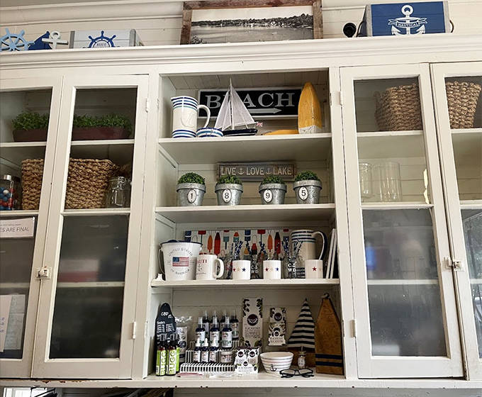 Glass cabinets showcase lakeside-themed dishware and decorative items perfect for cottage living.