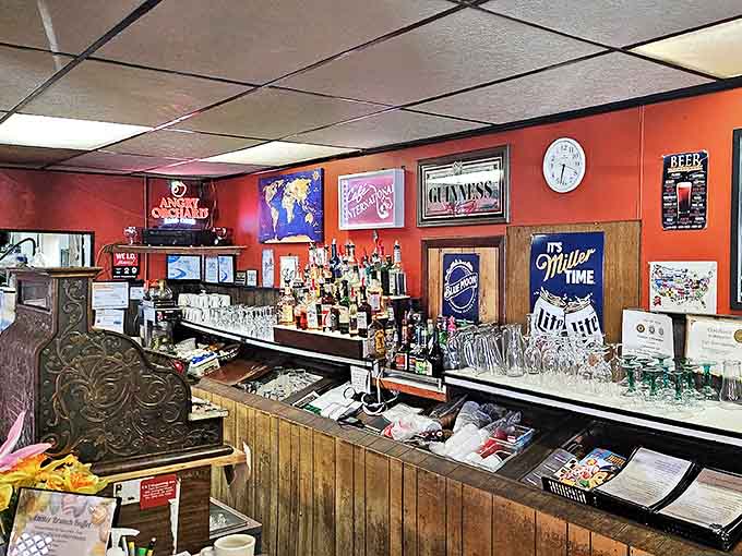 The bar area serves as the social heart of Caf&eacute; International, where local stories flow as freely as the beverages behind the rustic wooden counter.