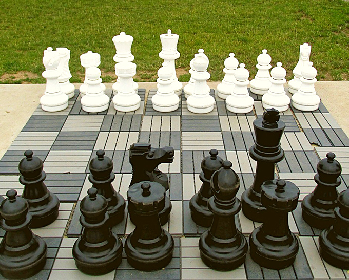 Strategic minds find their battlefield on this oversized chess board, where pieces move with dramatic flair and occasional rule-bending.