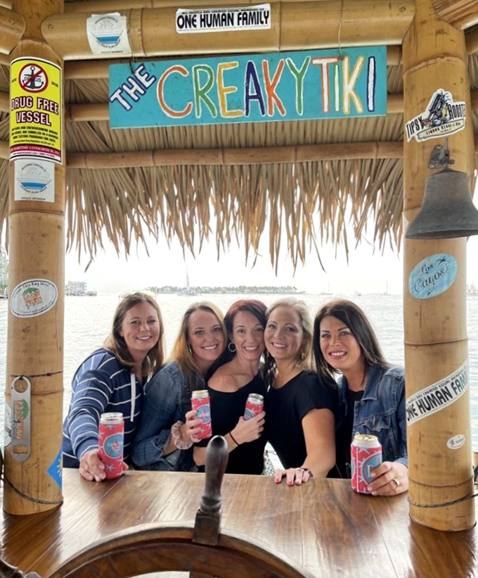 "The Creaky Tiki" sign frames this gathering spot where strangers quickly become friends in the intimate setting of a floating bar.