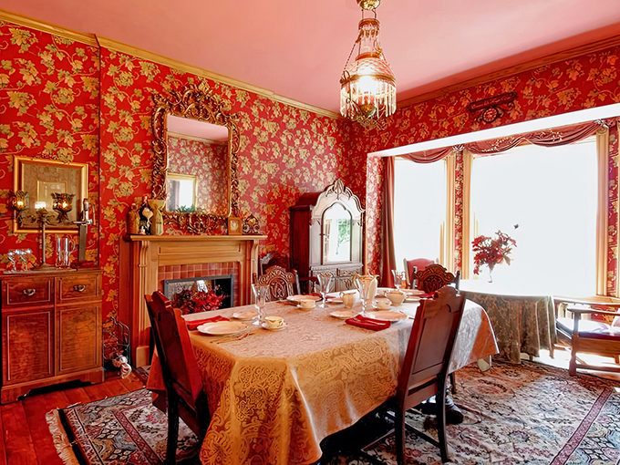 Dining Area: Rich red wallpaper and gleaming wood create a dining experience where even ordinary meals feel like special occasions from another century.