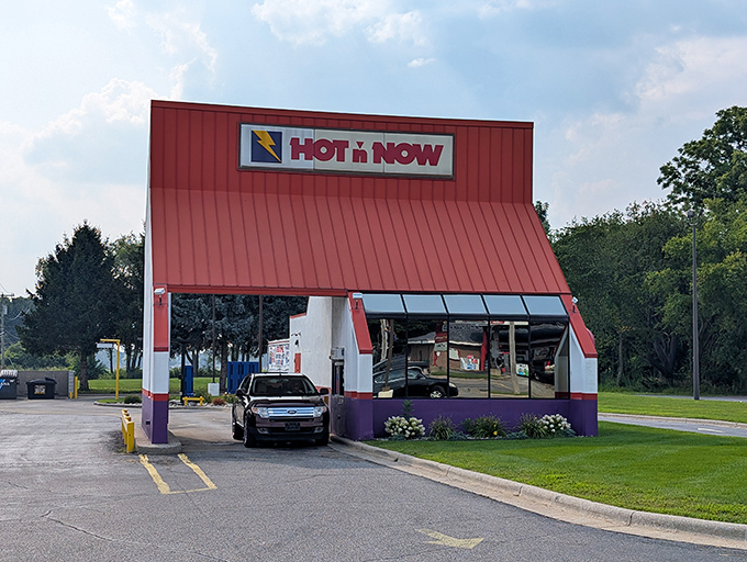 The drive-thru lane curves like a victory lap, each car inching forward with the mounting anticipation of burger bliss just moments away.
