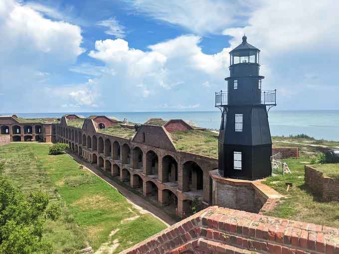 The lighthouse stands as a beacon against the endless blue horizon, guiding modern adventurers to this remote slice of paradise.