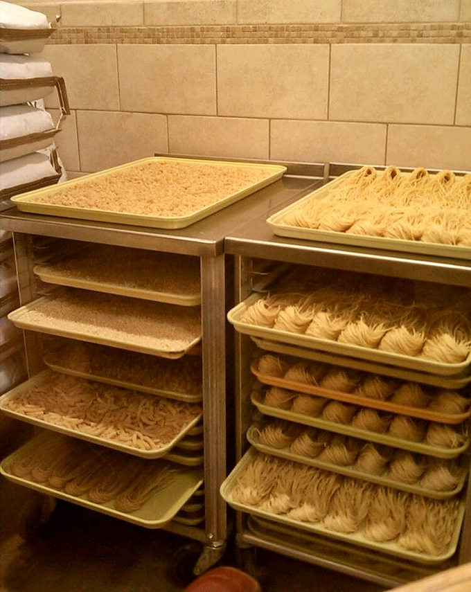 Behind the scenes, fresh pasta waits in orderly rows – the restaurant's commitment to handcrafted quality visible in each perfectly formed strand.