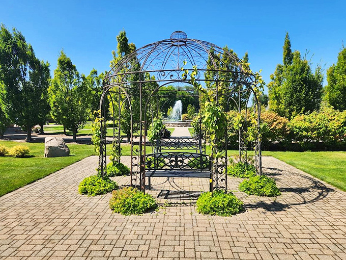 An ornate gazebo stands ready for romantic moments, having witnessed countless proposals, each one thinking they're the first to discover its charm.