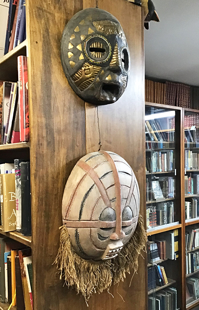 African masks watch over browsing bibliophiles, silent witnesses to the cultural conversations happening between covers and across centuries.