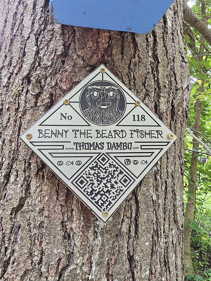 A metal plaque marks this as creation #118 in Thomas Dambo's worldwide collection of whimsical trolls made from recycled materials.