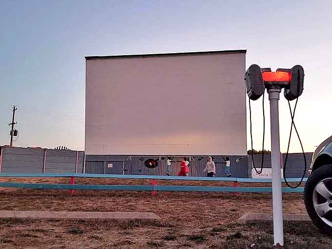 The massive screen stands ready against the darkening sky. Soon, stories larger than life will play out for an audience under stars.