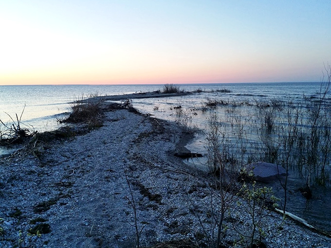 This narrow gravel point stretches into twilight waters, creating a magical pathway that seems to lead straight into the evening sky.