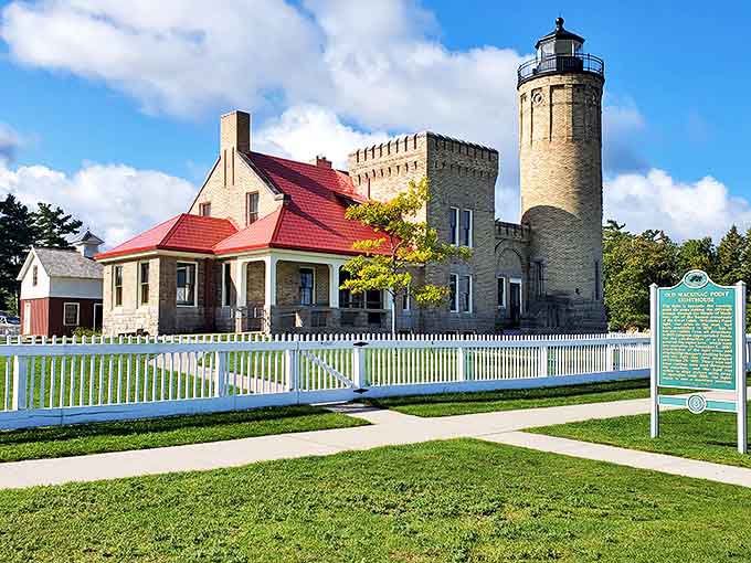 Old Mackinac Point Lighthouse stands proudly with its distinctive red roof, a Victorian-era beacon guiding ships through the same waters colonial vessels once navigated.