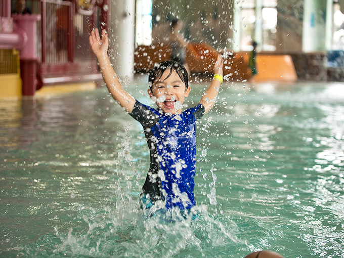 Pure joy erupts as a young water enthusiast creates the perfect splash, capturing the essence of carefree fun that defines the Avalanche Bay experience.