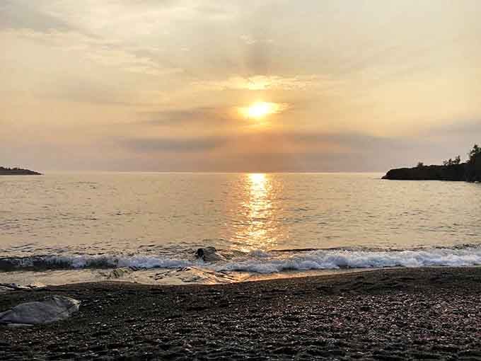 Golden hour magic: The sun's final rays transform Lake Superior into a sheet of liquid gold against the darkening shoreline.