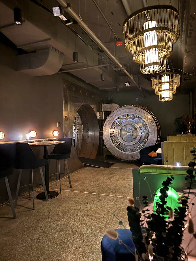 The massive bank vault door stands as a silent guardian of spirits, transforming what was once a secure space into something far more inviting.