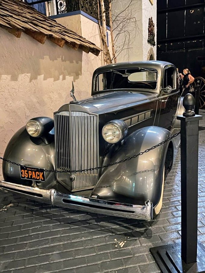 Stone steps spiral upward, bordered by crimson railings and mysterious sculptures that hint at wonders above.