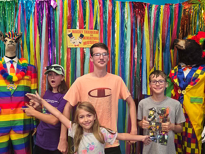Visitors pose with colorful taxidermy creations, proving this museum delivers family fun that's anything but ordinary.