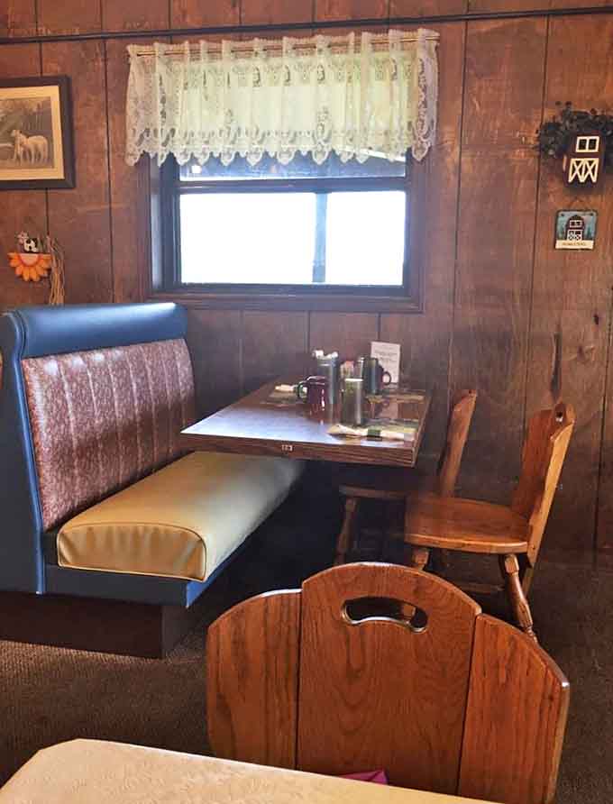 Cozy booth seating with wood paneling and lace curtains creates that quintessential small-town restaurant atmosphere we all crave.