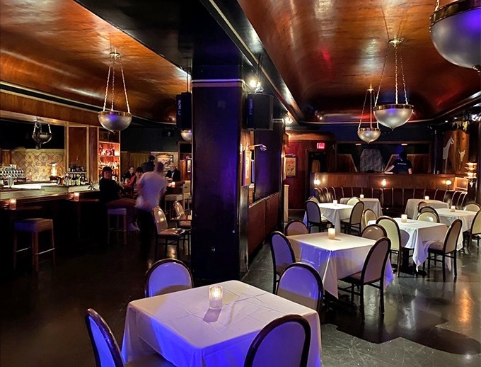 The dining room balances intimacy with energy, where white tablecloths meet red lighting in a dance as smooth as the jazz being played.