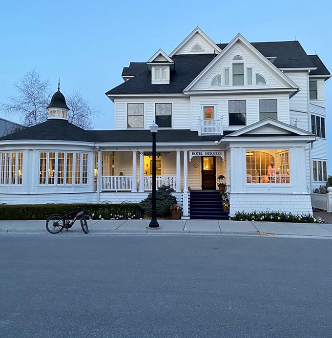 Twilight transforms the Hotel Iroquois into a glowing beacon of hospitality, its windows warm with invitation against the evening sky.