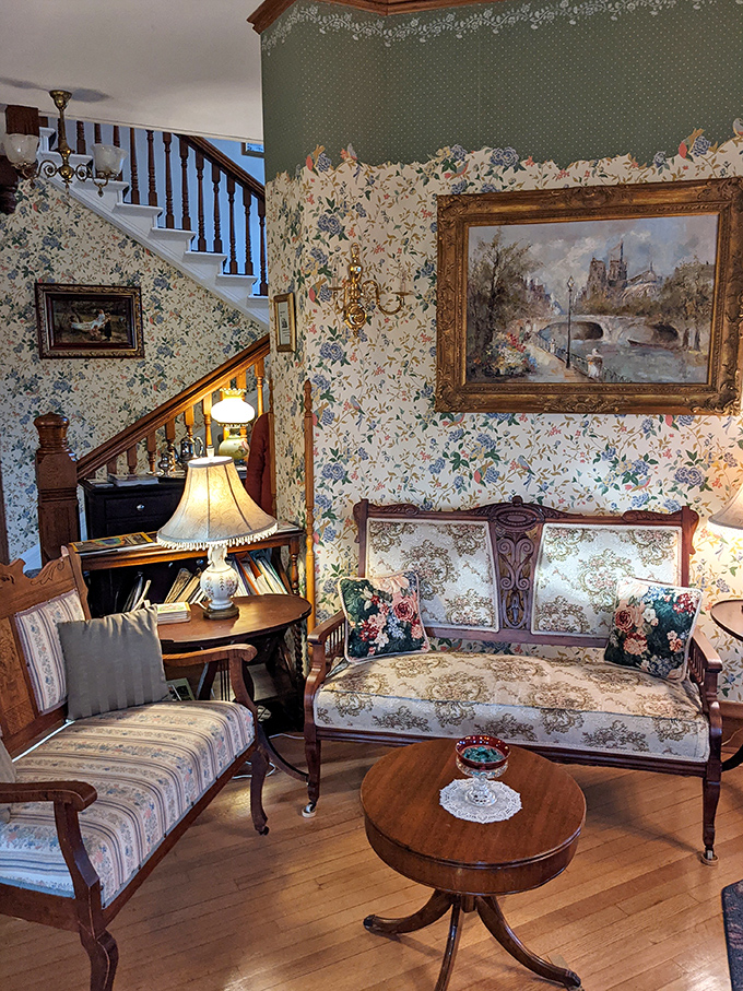 Floral patterns engage in a friendly competition across furniture, wallpaper, and rugs in this cozy Victorian sitting area.