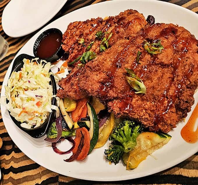 Pecan-crusted rainbow trout proves the kitchen takes its cooking seriously, even when surrounded by mechanical elephants and fake thunderstorms.